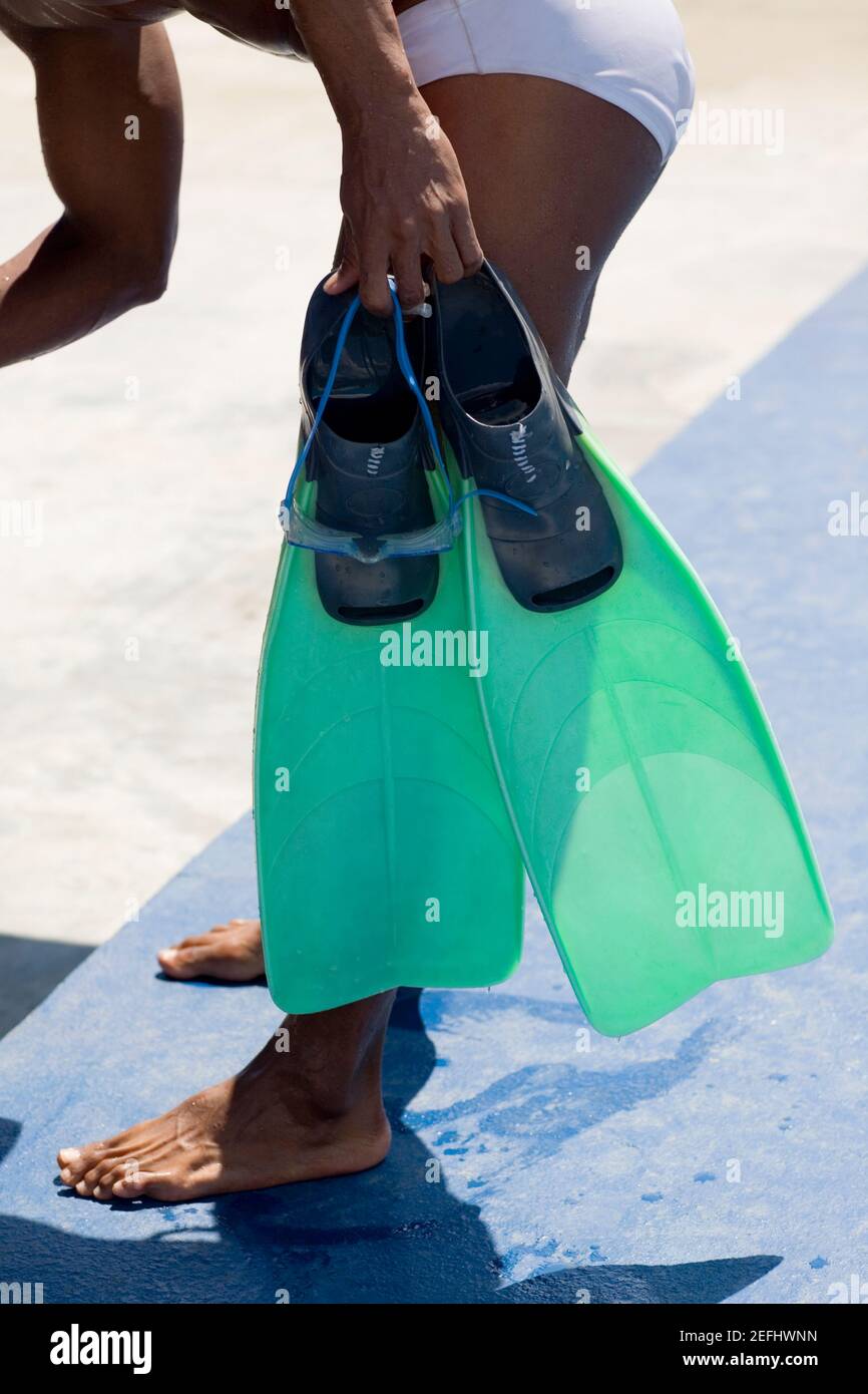 Side profile of a mid adult man holding a pair of flippers Stock Photo ...
