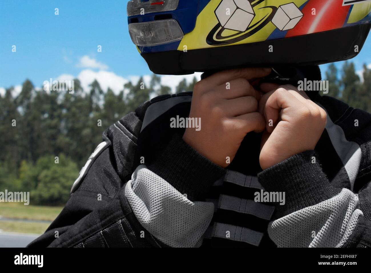 Close-up of a person adjusting his crash helmet Stock Photo - Alamy
