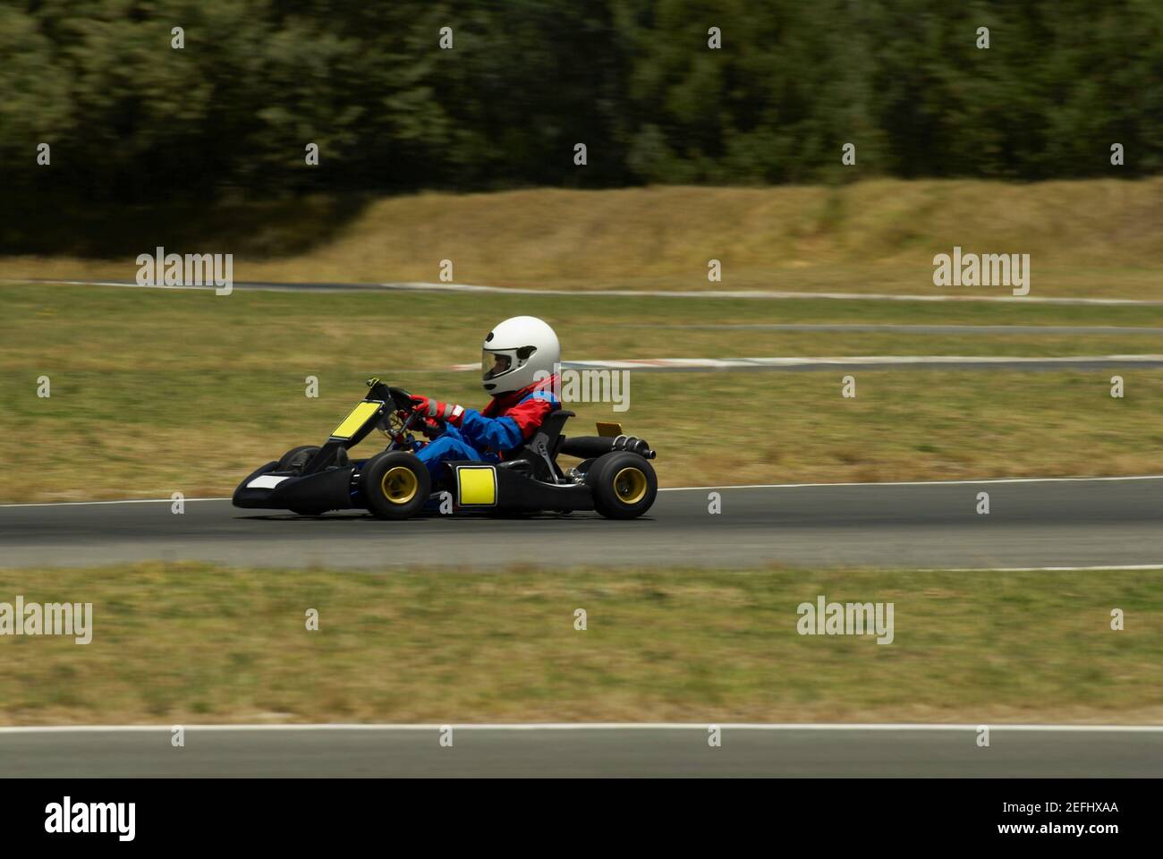 Side profile of a person go-carting on a motor racing track Stock Photo ...