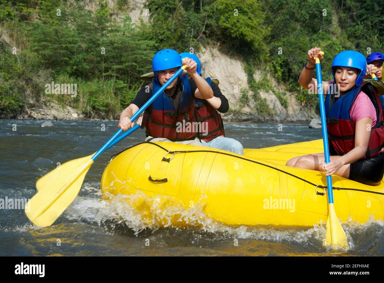 Four people rafting in a river Stock Photo - Alamy