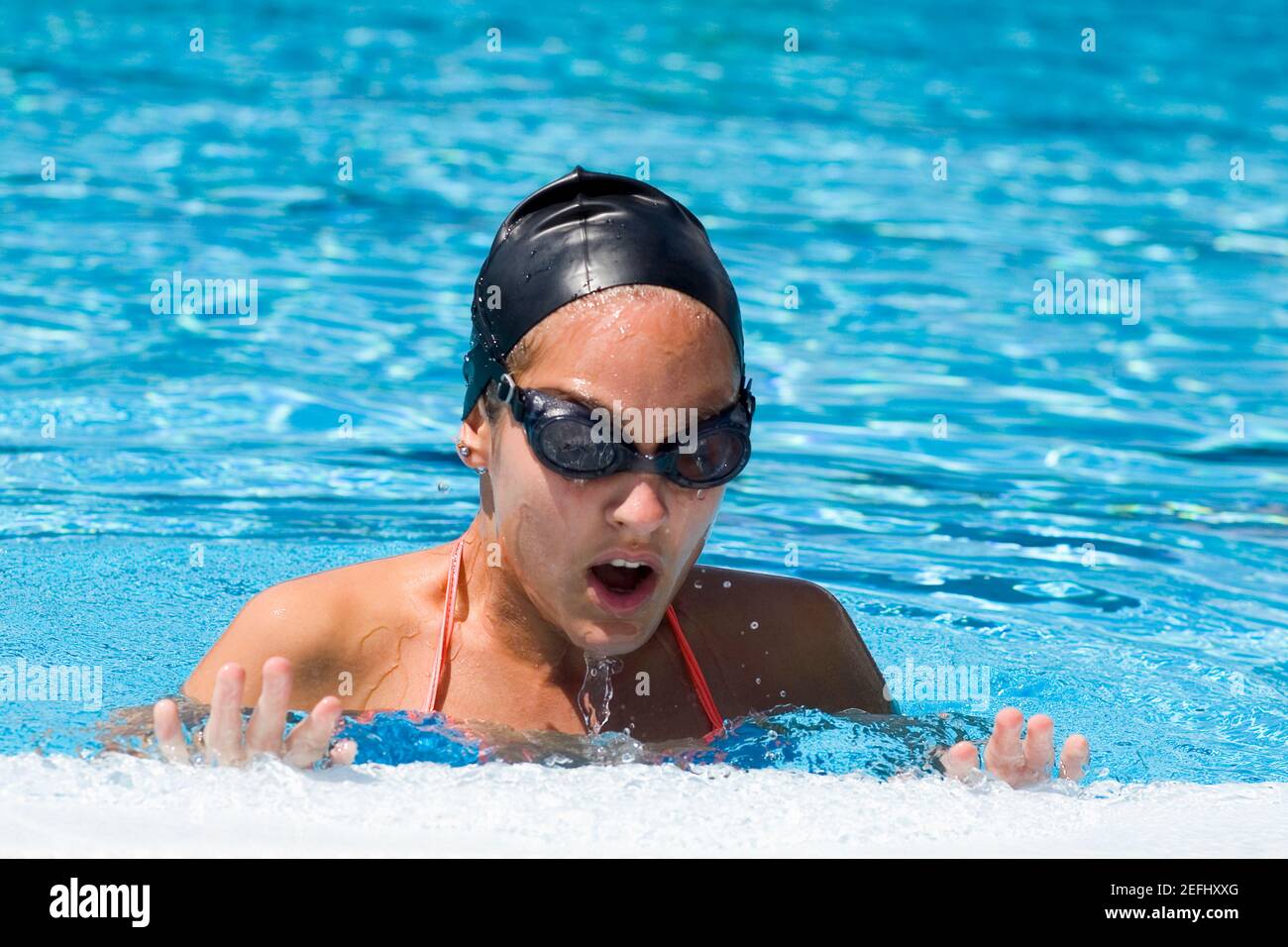 Young woman leaning on the ledge of a swimming pool Stock Photo - Alamy