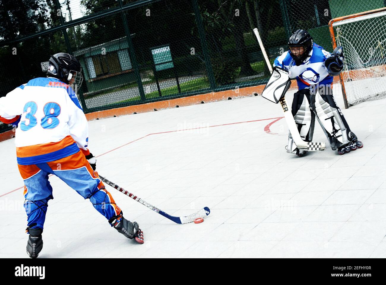 Two boys playing ice hockey Stock Photo - Alamy