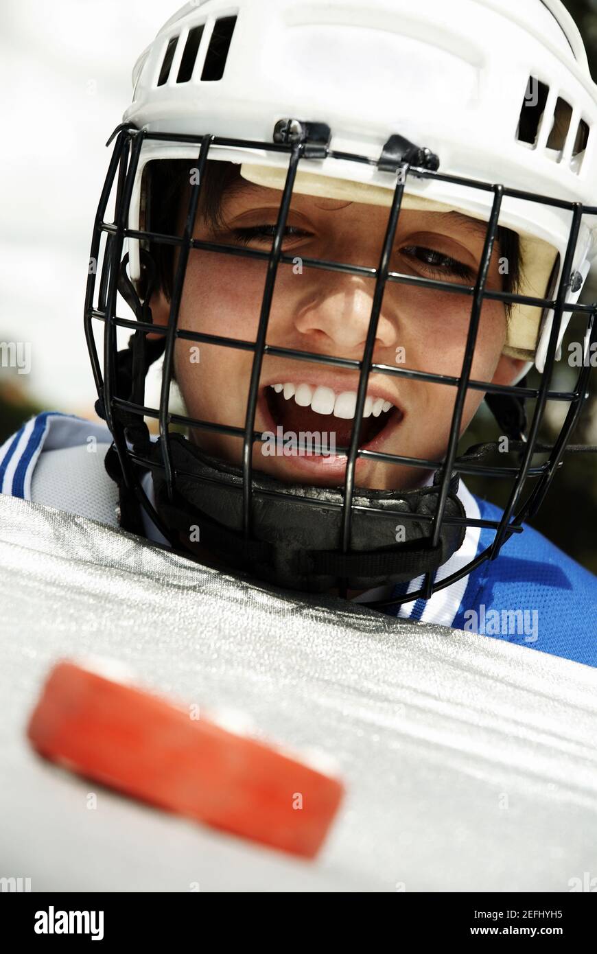 Close up of a boy looking at a hockey puck and laughing Stock Photo - Alamy