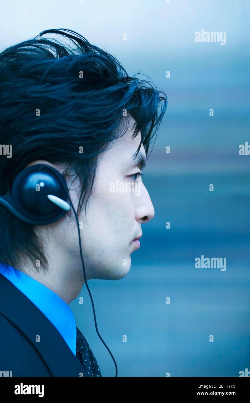 Side profile of a businessman wearing headphones Stock Photo - Alamy