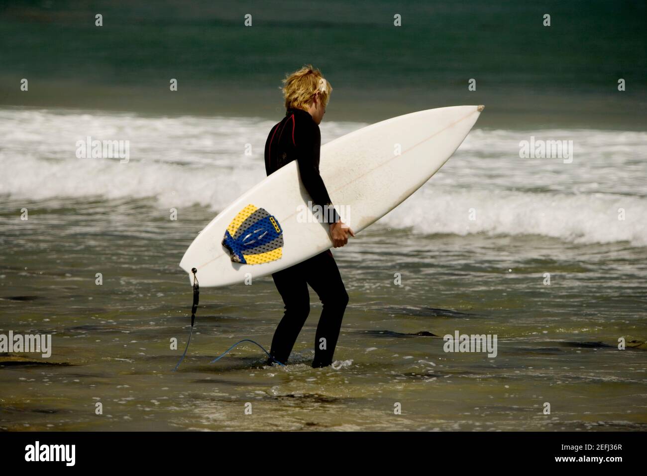 Side profile of a man carrying a surfboard Stock Photo - Alamy