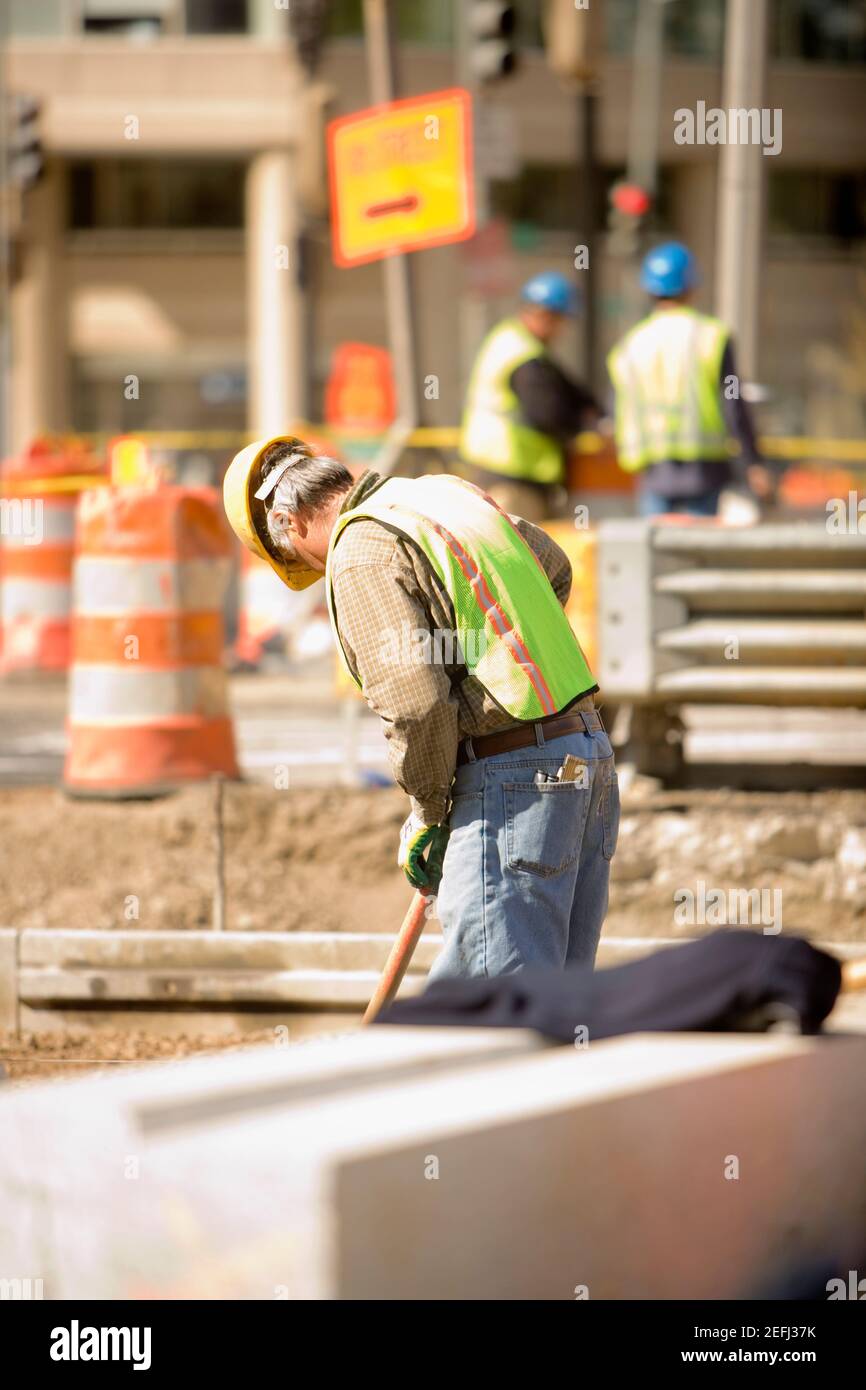 Side profile of a construction worker working at a construction site ...