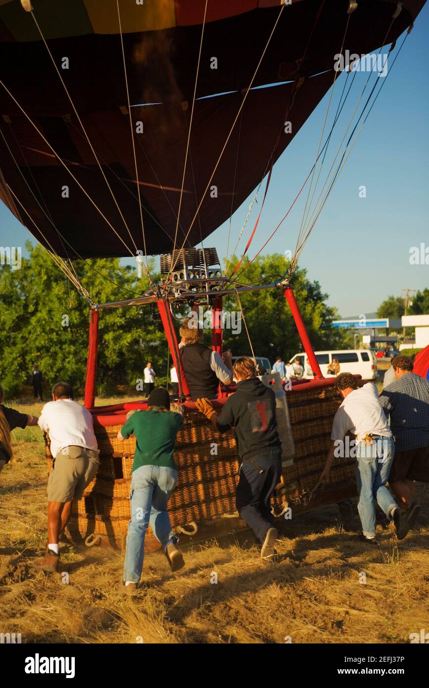 Rear view of people pulling hot air balloon Stock Photo - Alamy