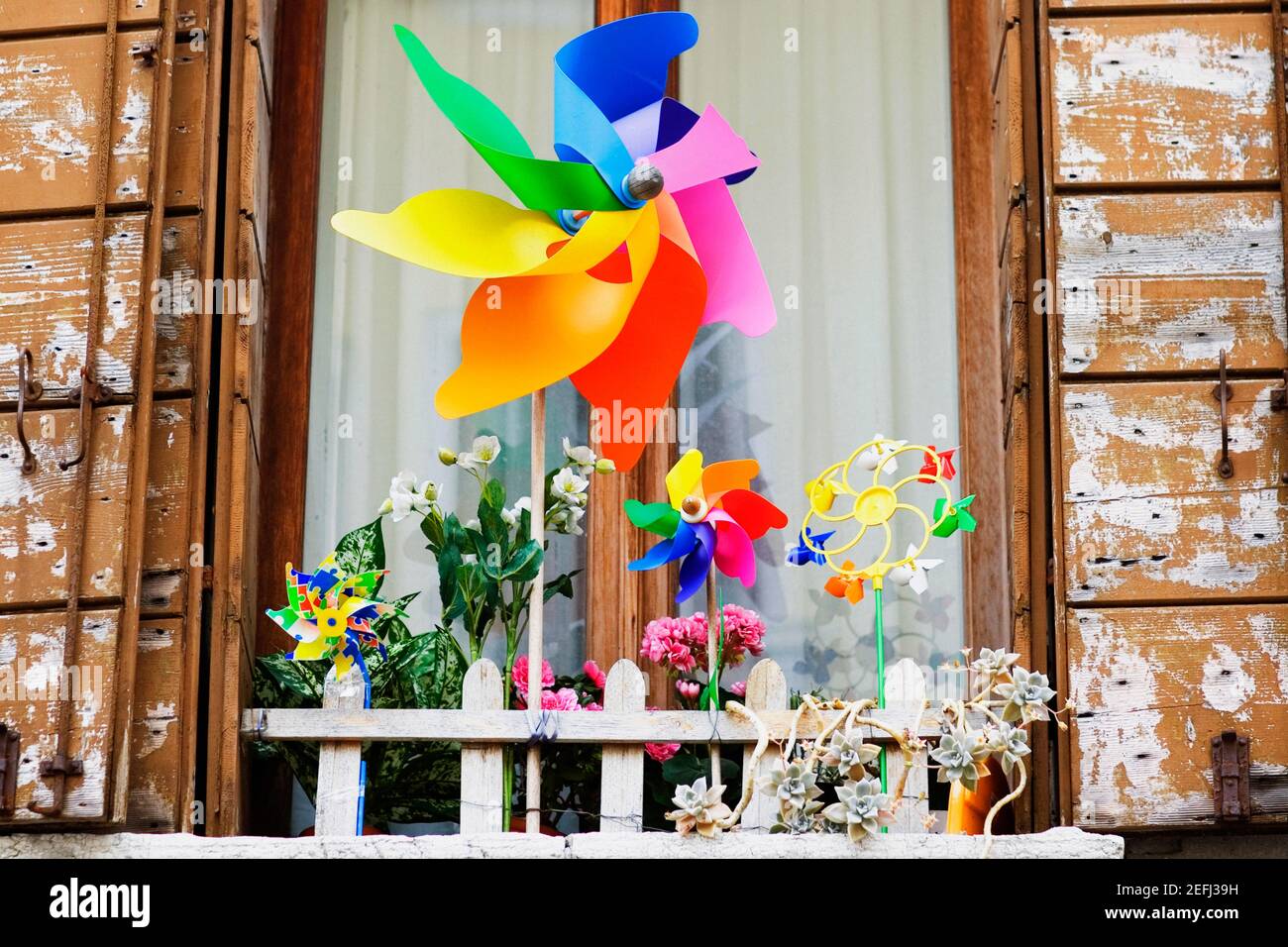 Low angle view of pinwheels in front of a window Stock Photo - Alamy
