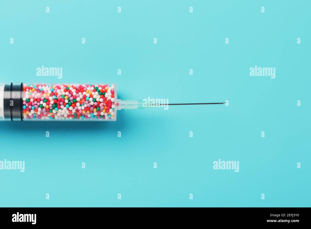Syringe with colorful balloons on a blue background with free space ...