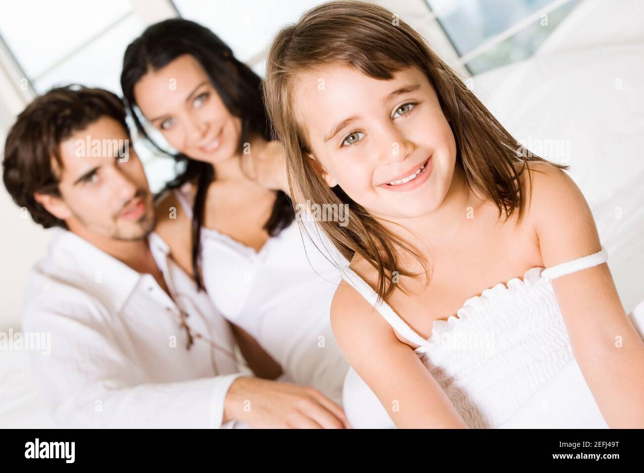 Portrait of a girl smiling with her parents behind her Stock Photo - Alamy