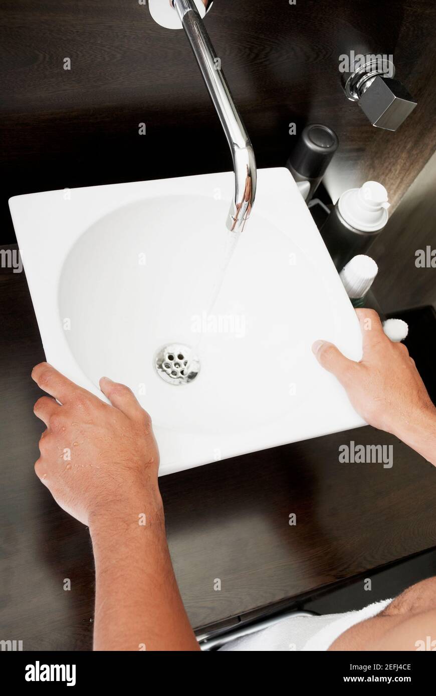 Mid section view of a person standing in front of a bathroom sink Stock ...