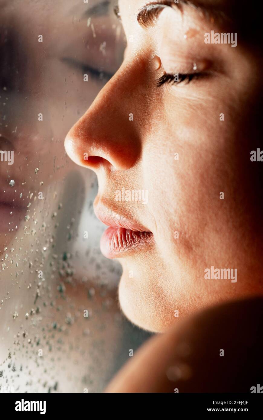Woman leaning against glass window hi-res stock photography and images ...