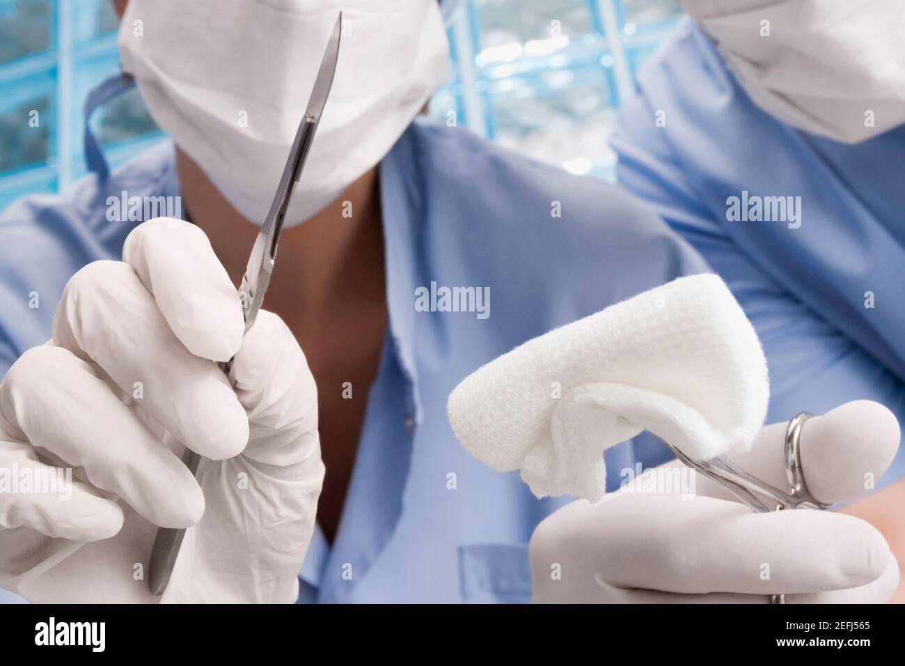 Two surgeons holding a scalpel and a surgical scissors Stock Photo - Alamy