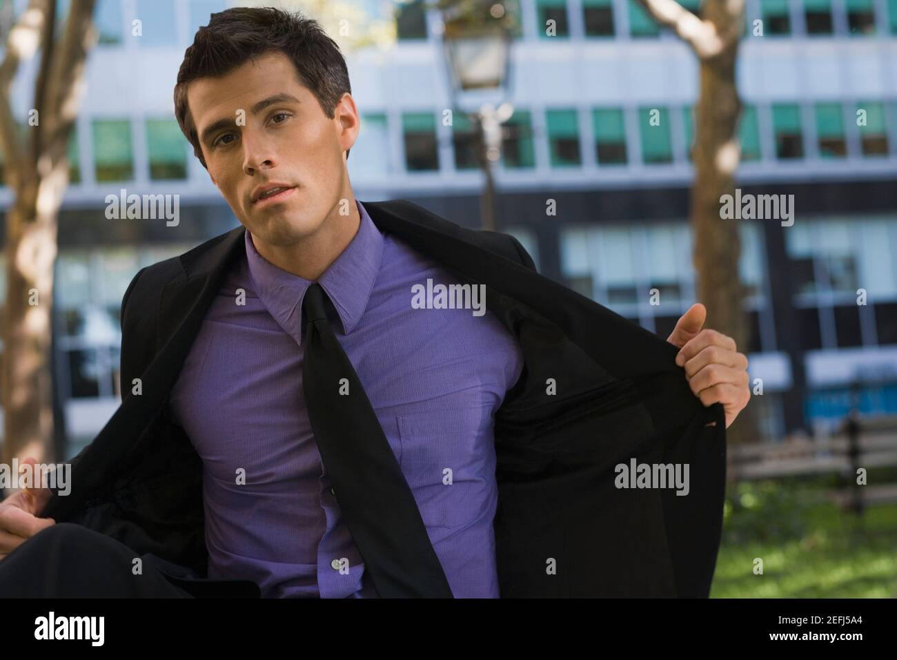 Portrait of a businessman putting off his coat Stock Photo - Alamy
