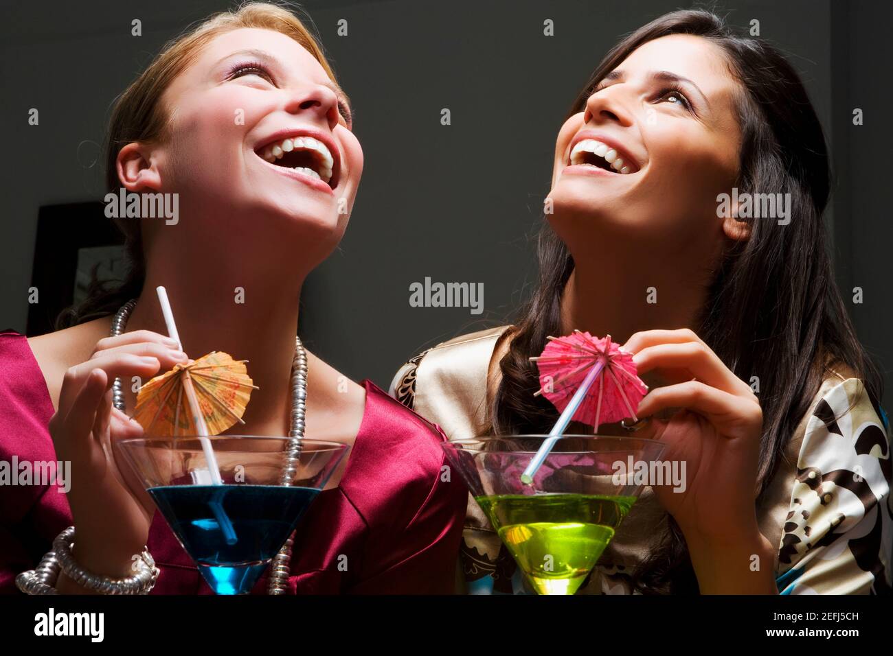 Two young women drinking cocktail and smiling Stock Photo - Alamy