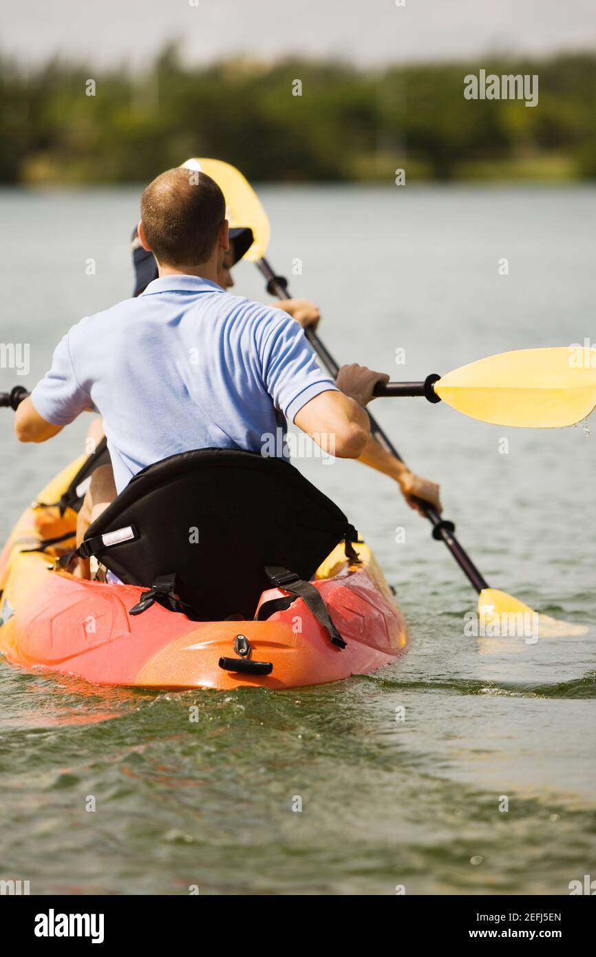 Rear view of a young man kayaking in a lake Stock Photo - Alamy