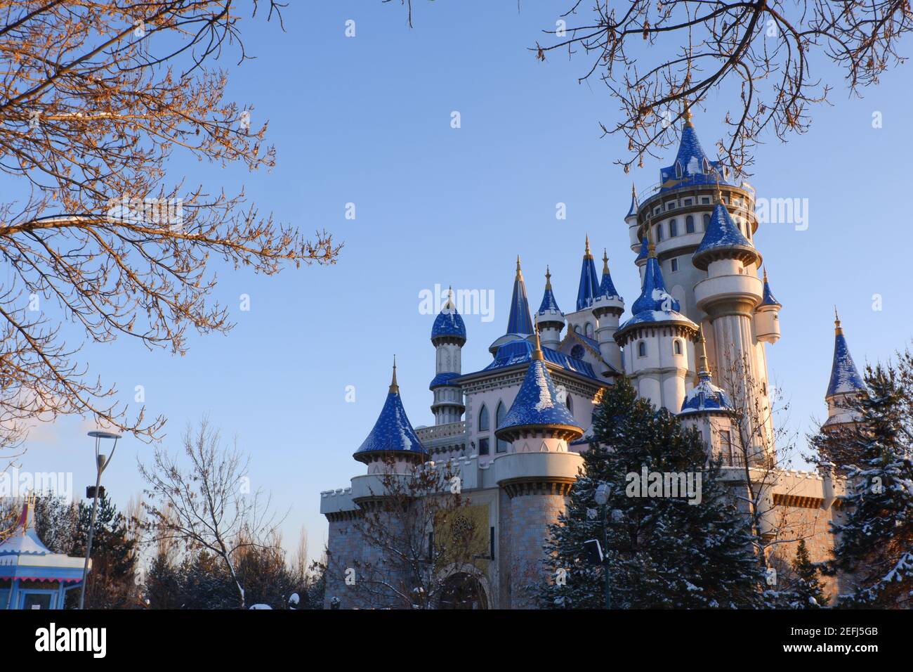 Nostalgic Blue Castle Behind Trees Under snow Stock Photo - Alamy