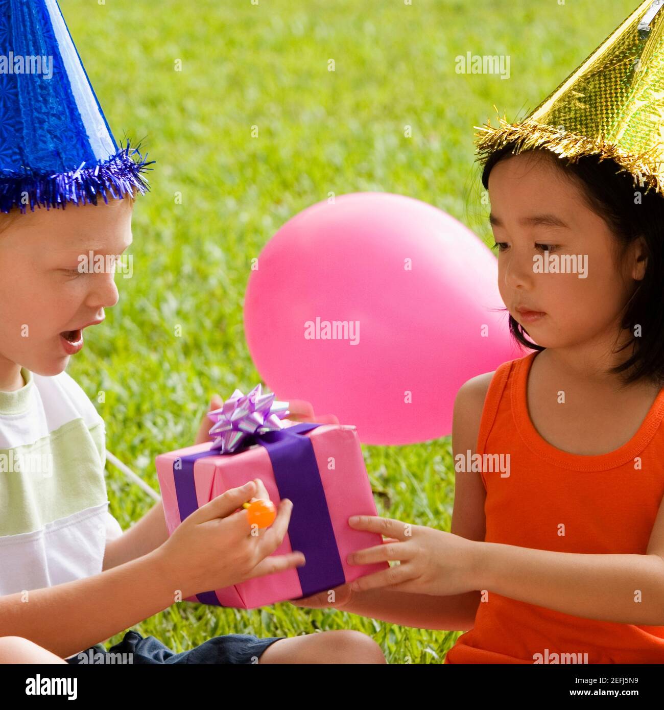 Close up of a boy giving a birthday present to a girl Stock Photo - Alamy