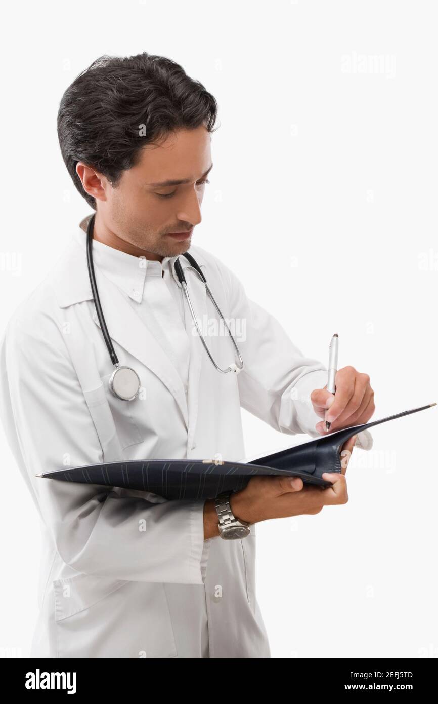 Male doctor writing in a file Stock Photo - Alamy