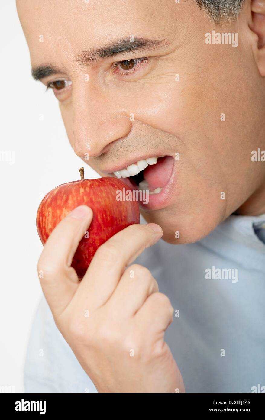 Mid adult man eating apple hi-res stock photography and images - Alamy