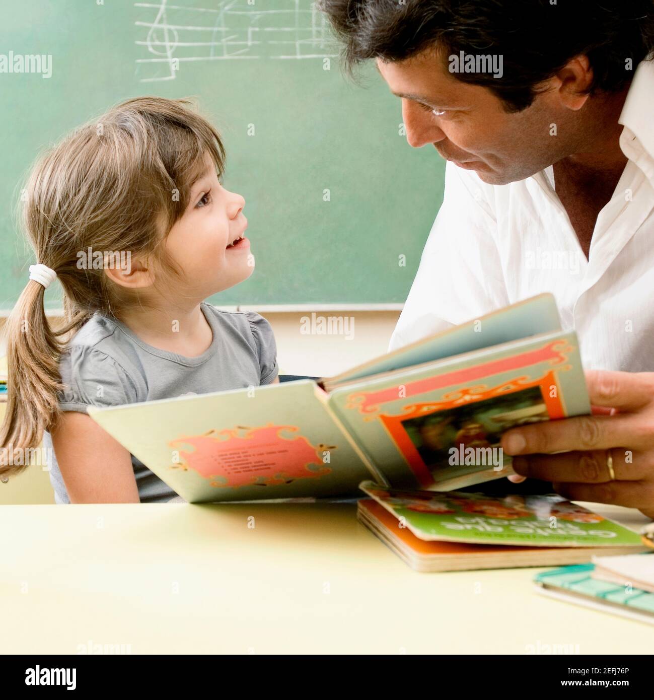 Male teacher teaching his student in a classroom Stock Photo - Alamy