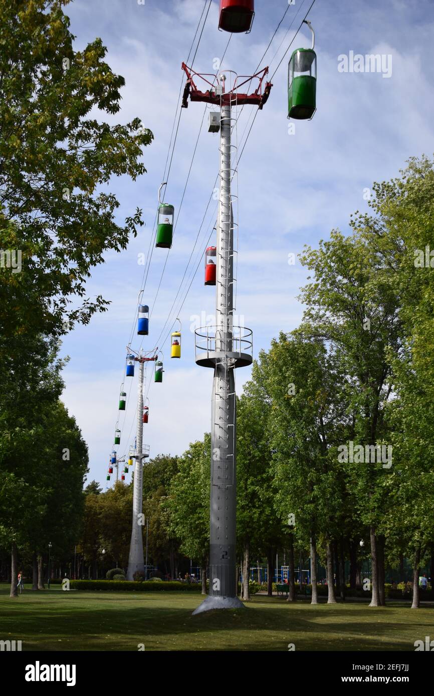 Brightly colored cable cars carry tourists. Running on wires supported ...