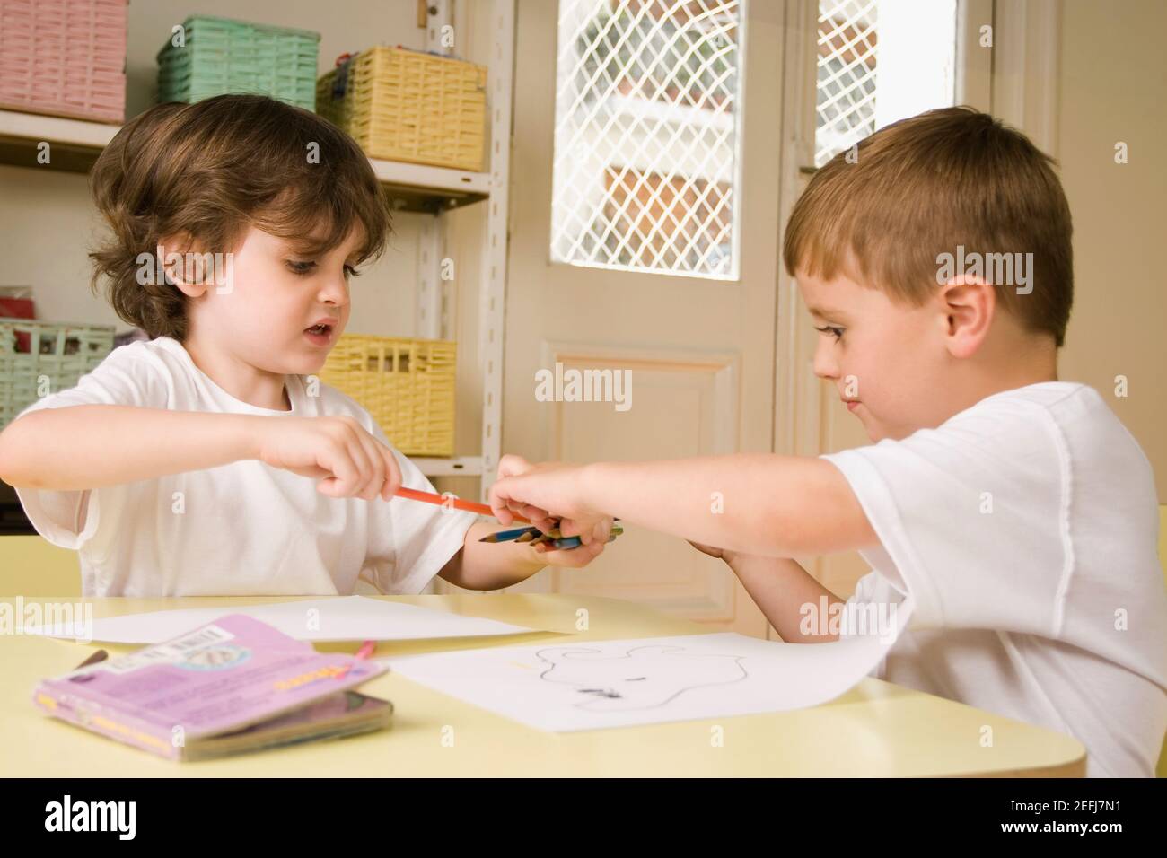 Boy snatching a pencil from a girl in a classroom Stock Photo - Alamy