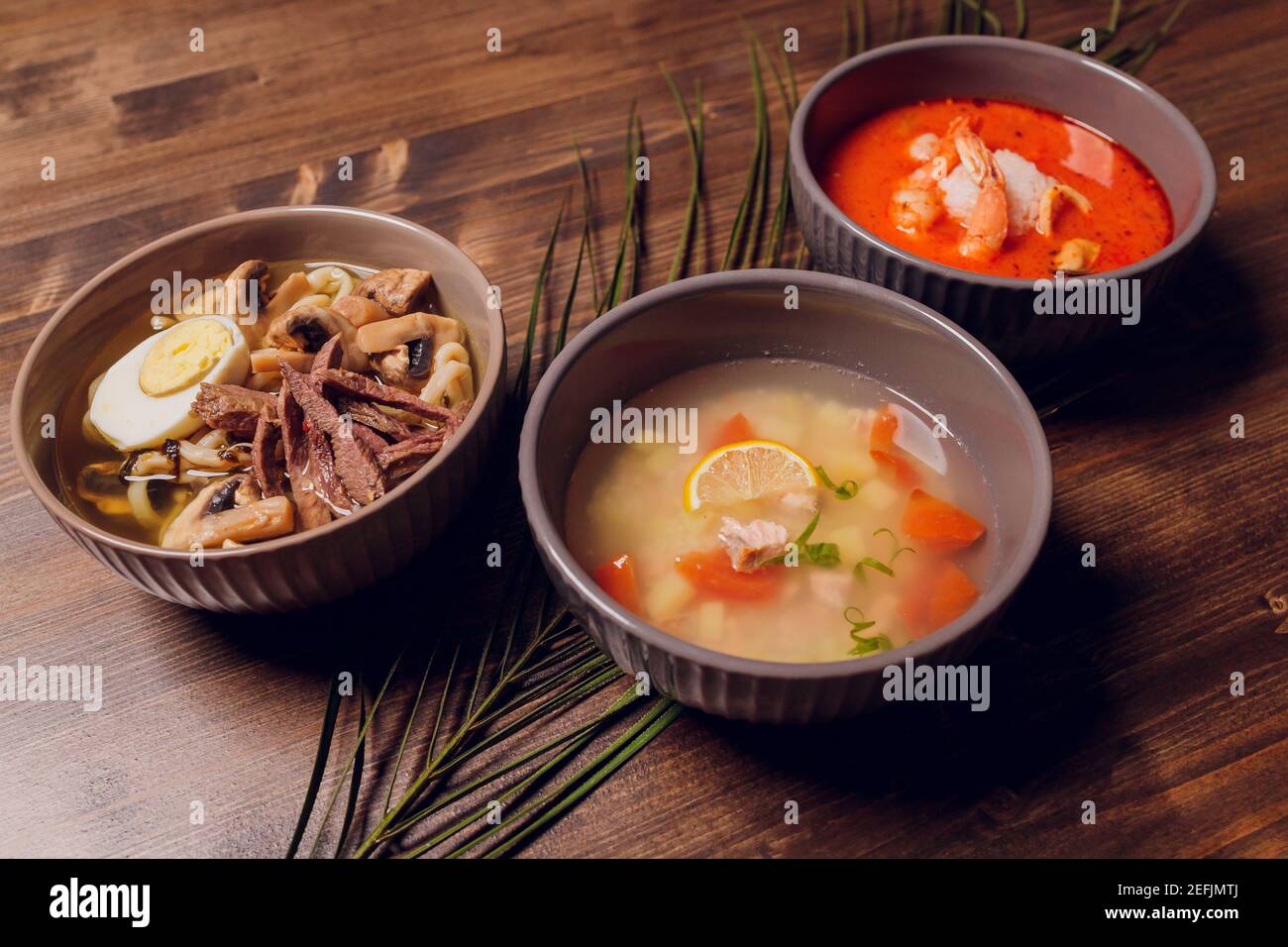 Set of Serving Asian Soups on gray background top view. Tom Yum Soup ...
