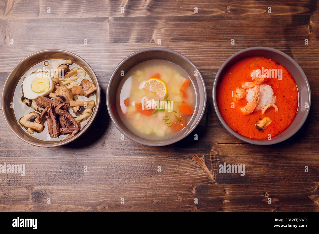 Set of Serving Asian Soups on gray background top view. Tom Yum Soup ...