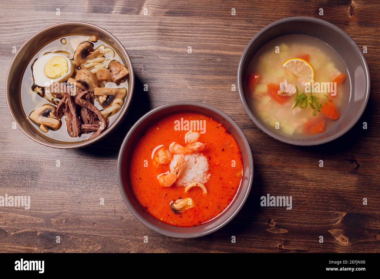Set of Serving Asian Soups on gray background top view. Tom Yum Soup ...
