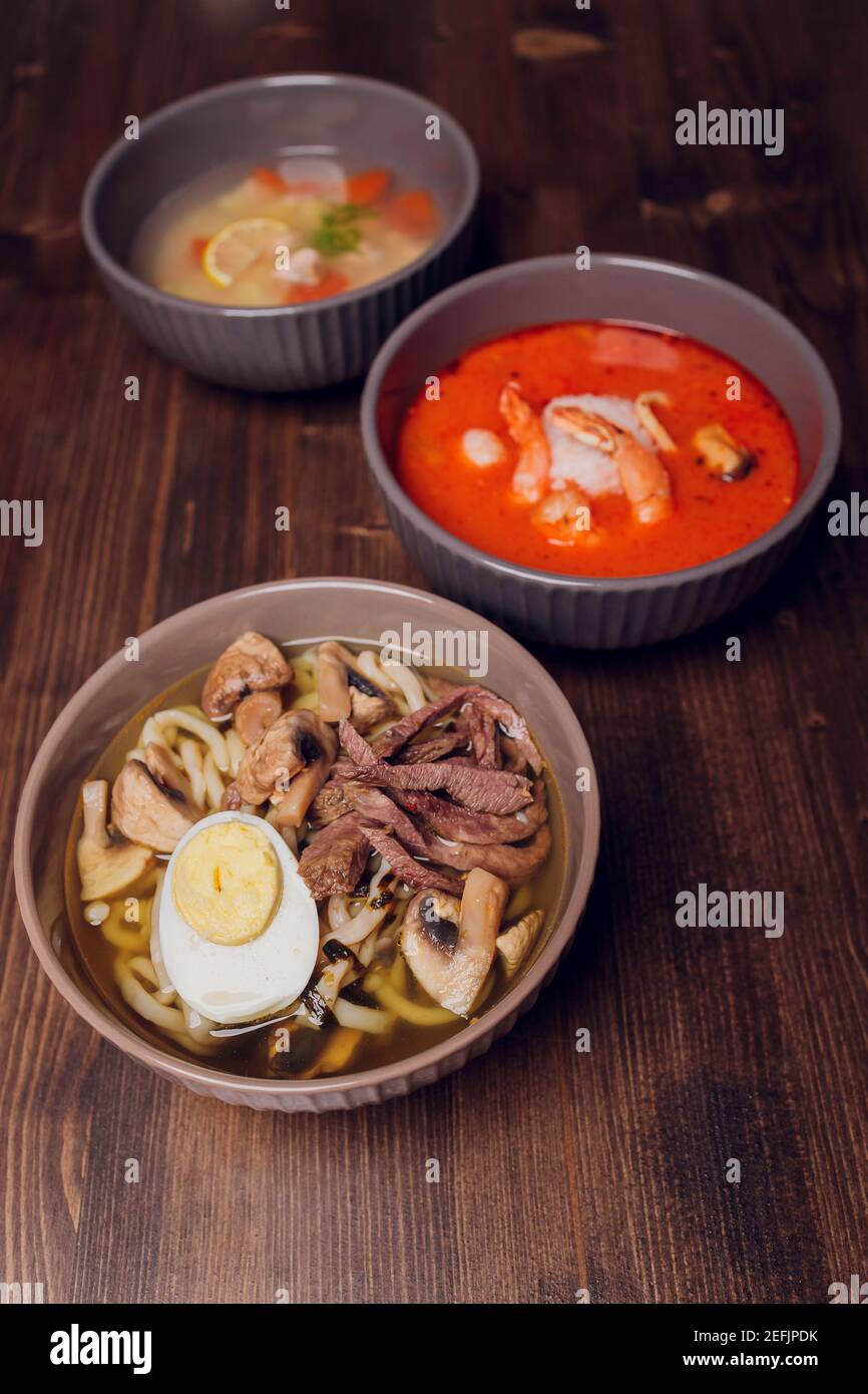 Set of Serving Asian Soups on gray background top view. Tom Yum Soup ...