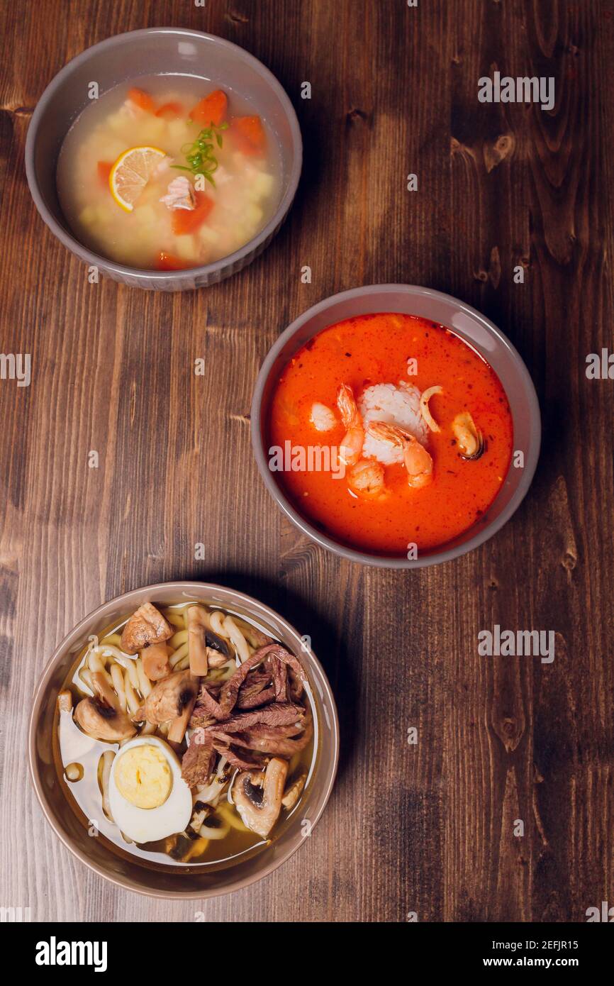 Set of Serving Asian Soups on gray background top view. Tom Yum Soup ...