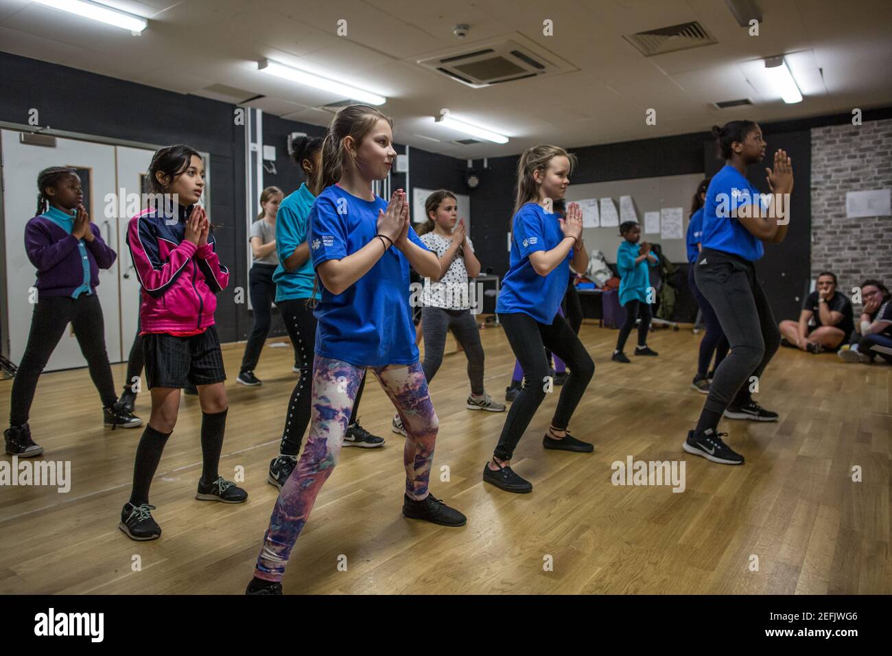 Schoolchildren participate in an indoor Physical Education (PE) lesson ...