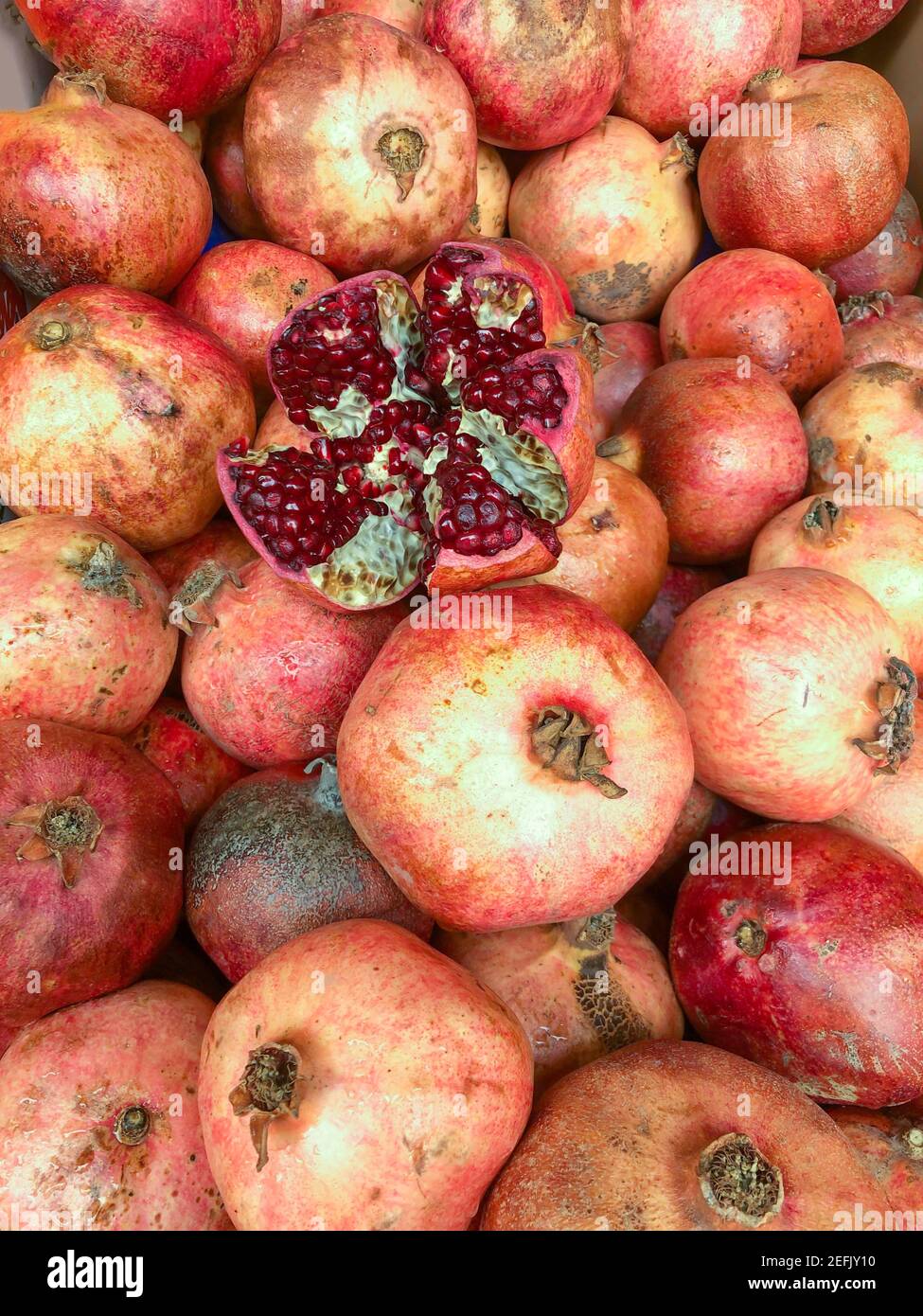 one opened and whole pomegranate fruits in the supermarket Stock Photo ...