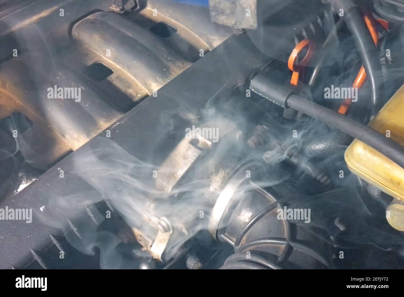 Smoke under the hood of a car. Car engine smokes Stock Photo - Alamy