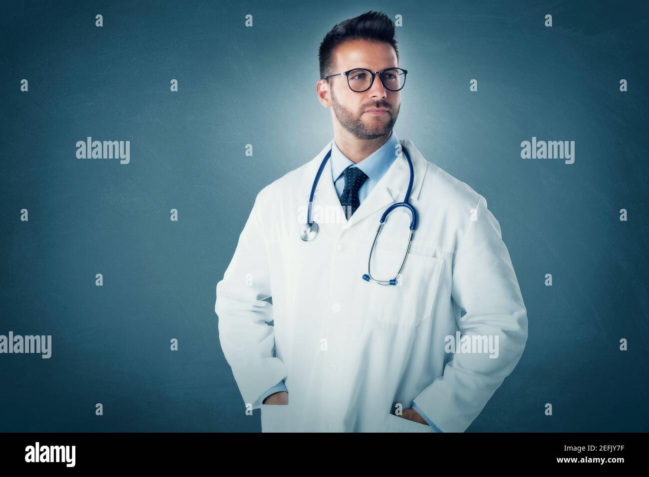 Studio portrait of male doctor standing at isolated background while ...