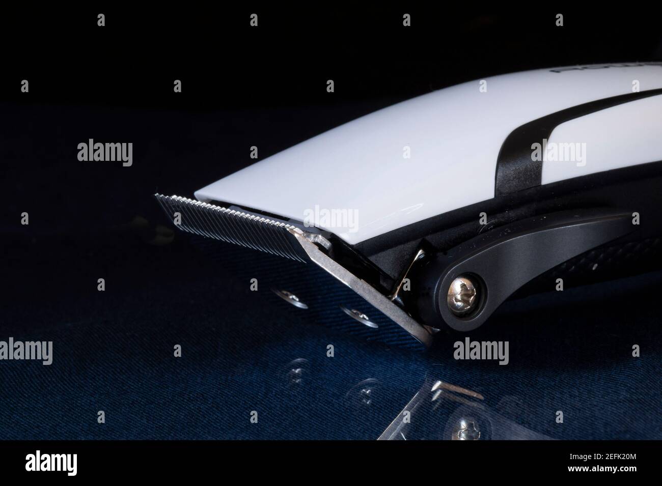 An electric razor for cutting hair is lying on a glass table. Equipment ...