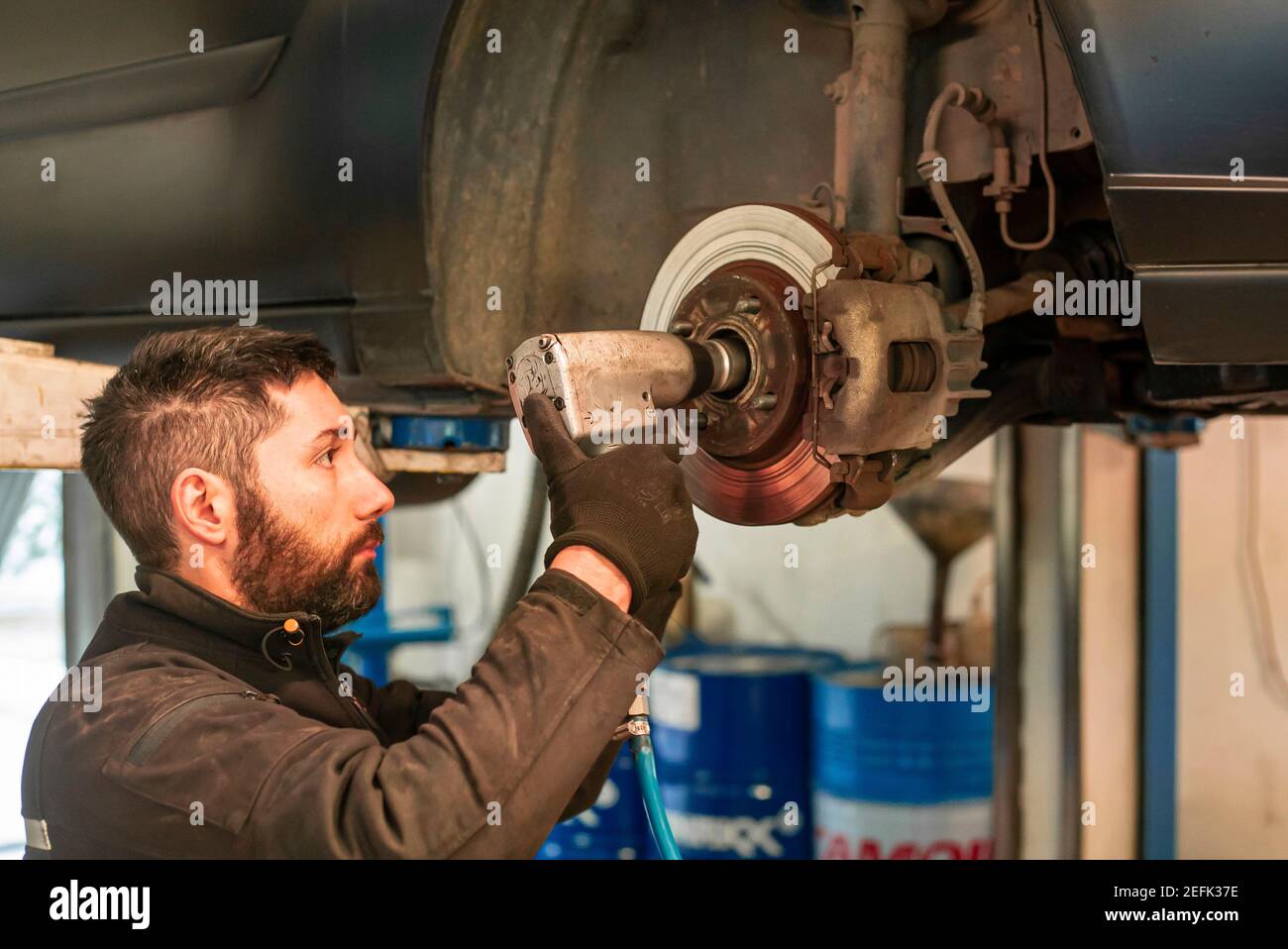 Mechanic performs maintenance on the car in the workshop Stock Photo ...