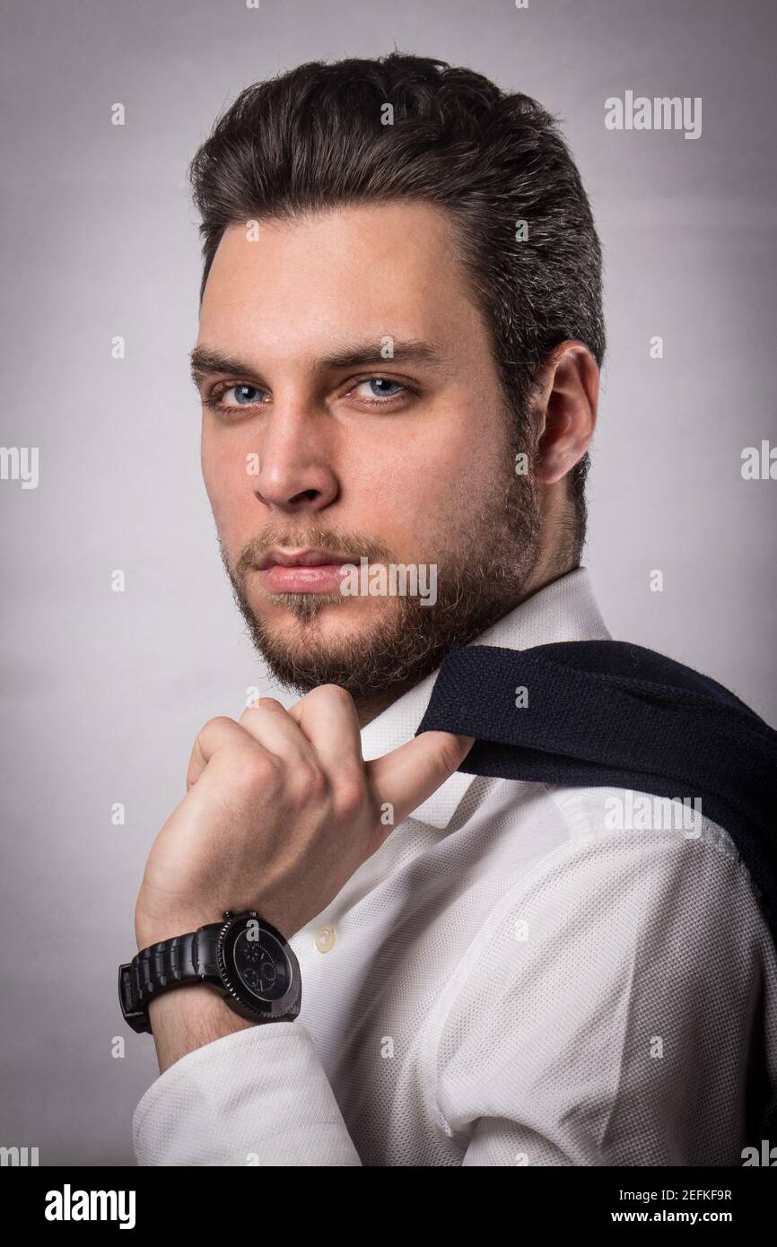 White businessman poses dressed in an elegant white shirt and leans a ...