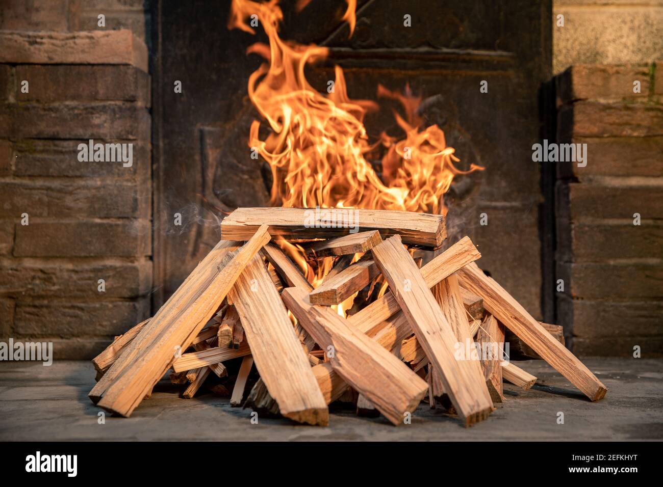 Closeup of pyre of burning wood with flames. Production of charcoal for ...