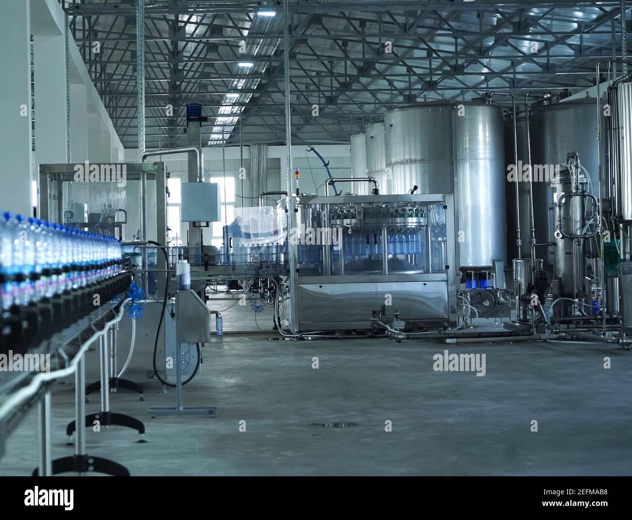 Filling line of sparkling water in a pet bottle. Mini factory for ...