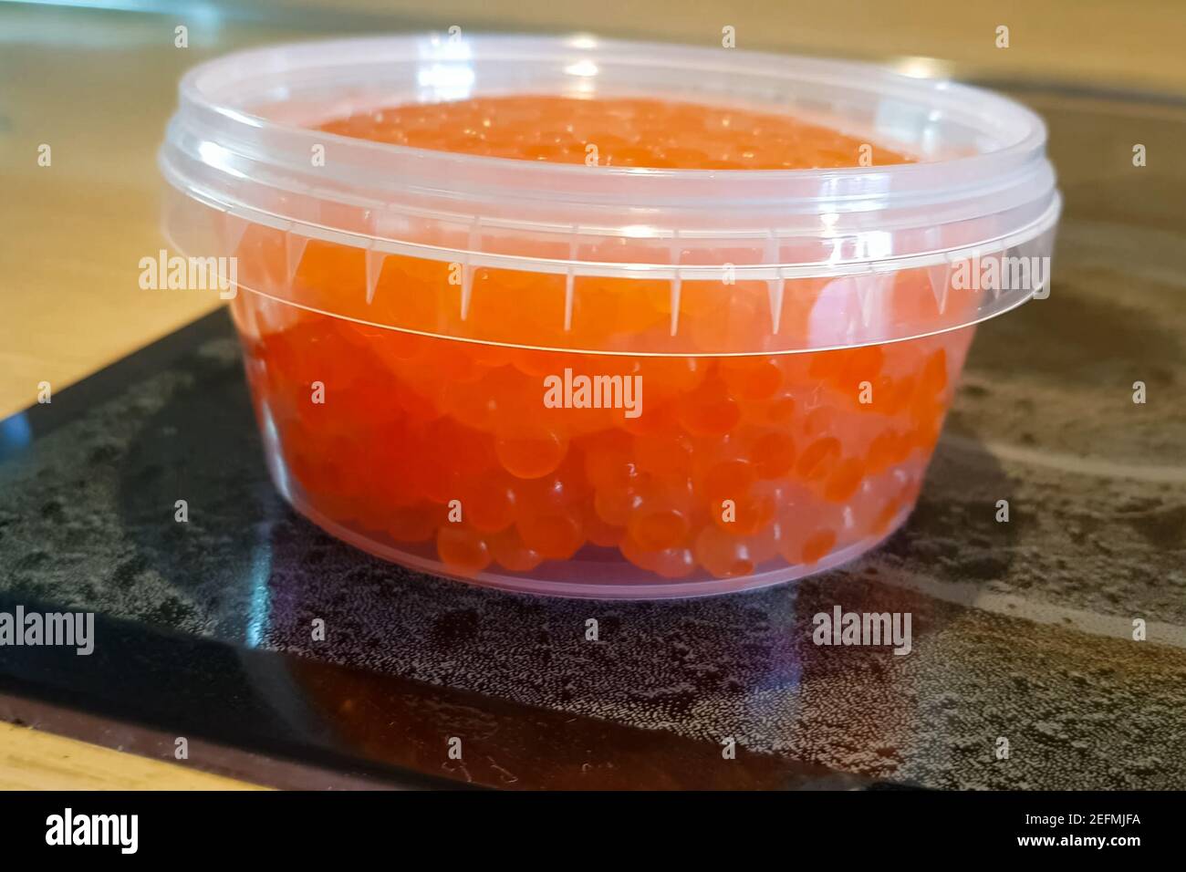 Fresh red caviar in a plastic transparent container Stock Photo - Alamy
