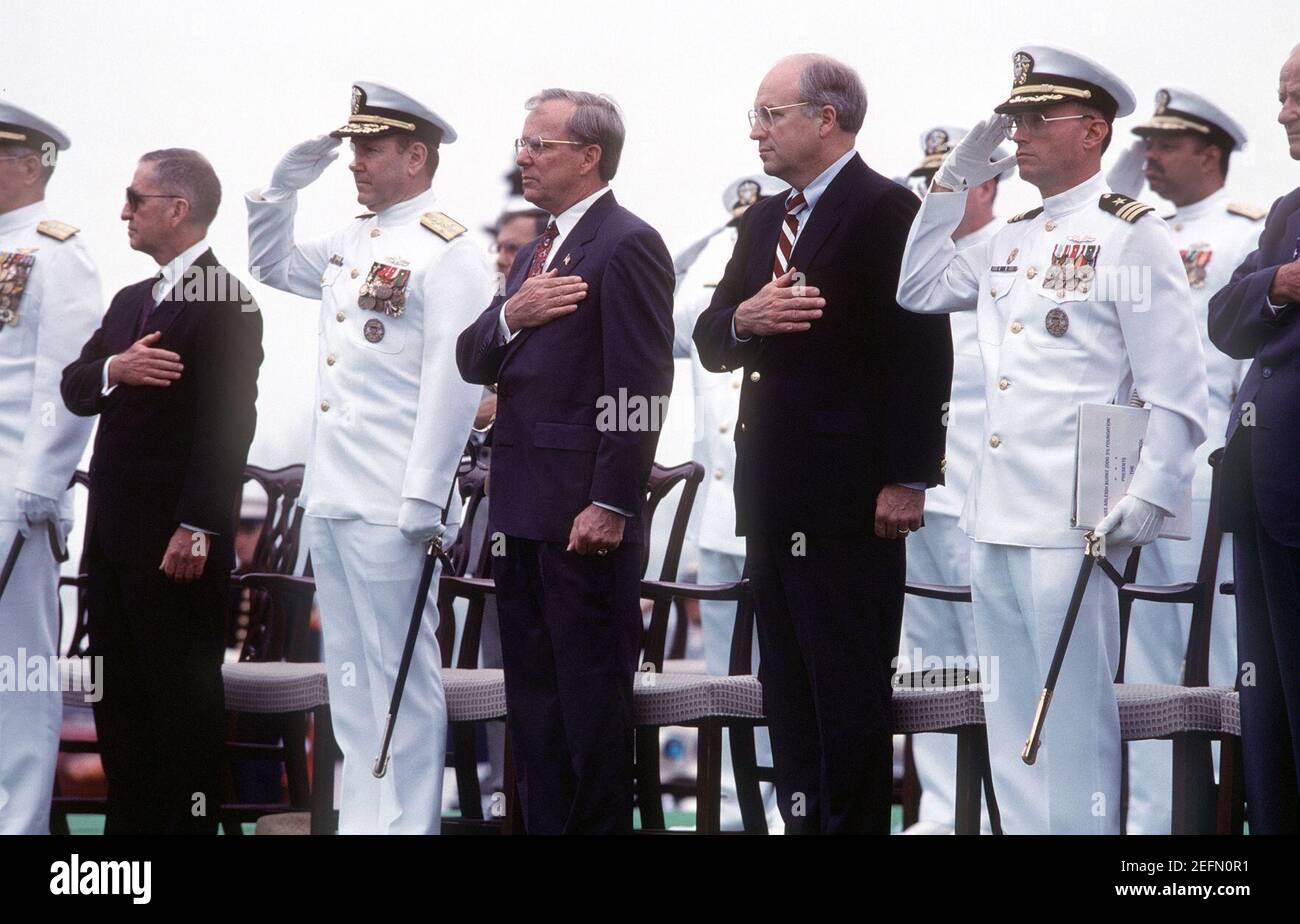 Officers and distinguished guests stand during the National Anthem at ...