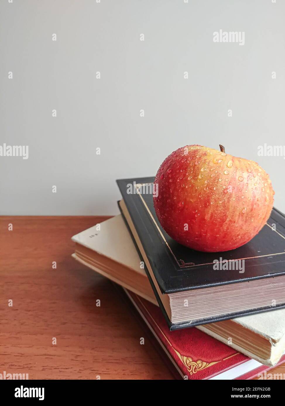 Stack of books and apple on top Stock Photo - Alamy