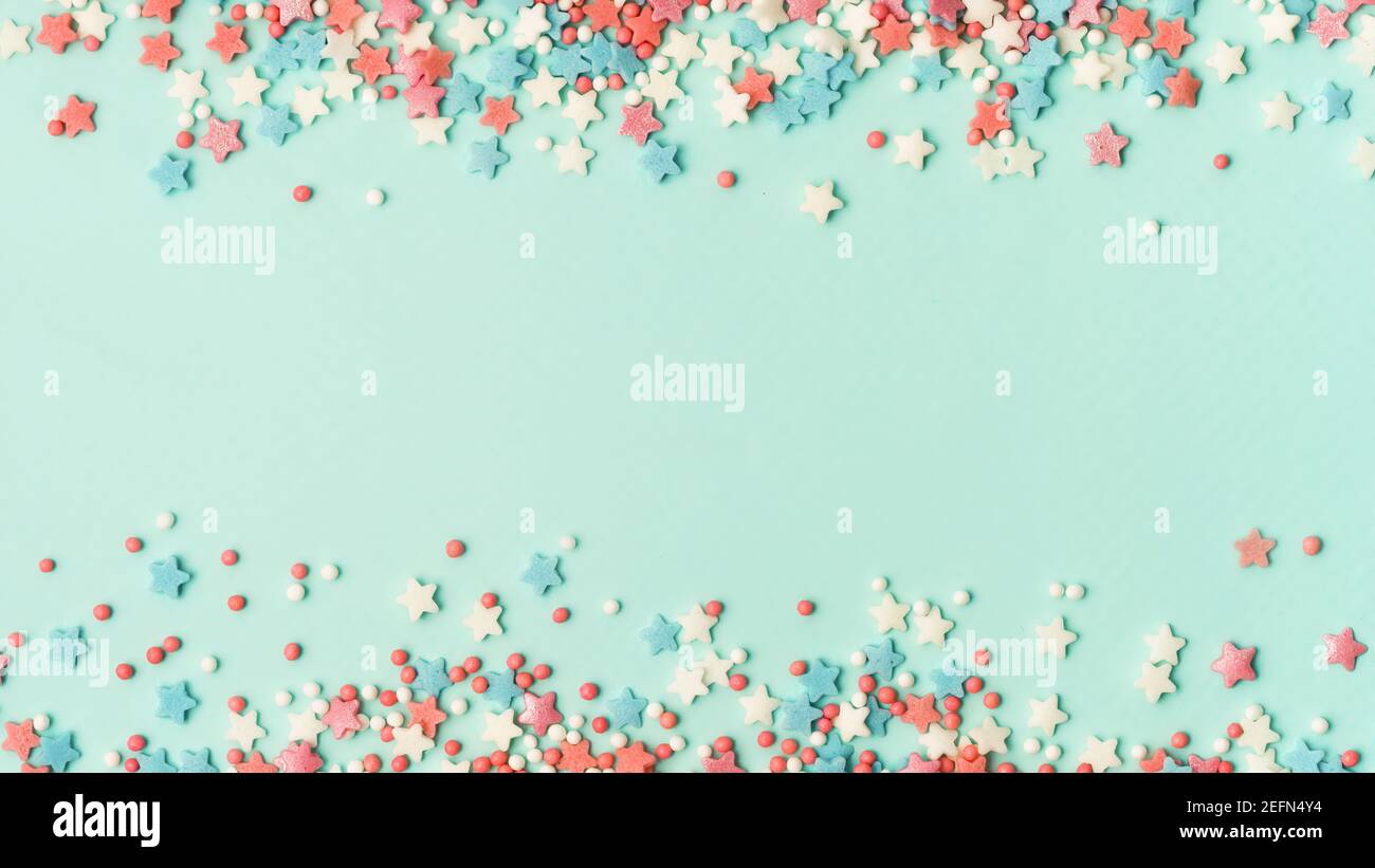 Festive border frame of colorful pastel sprinkles on blue background ...