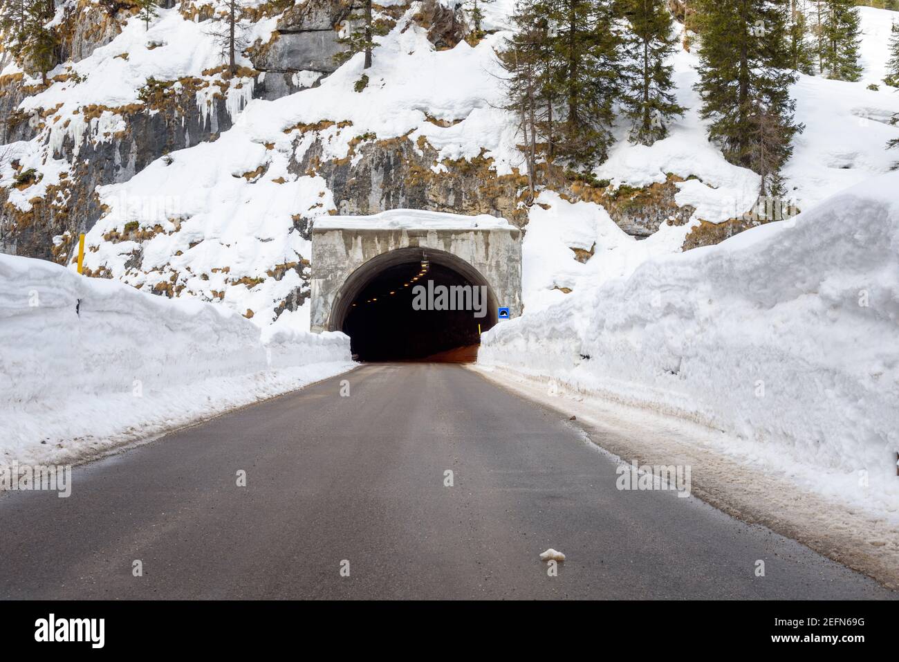 Entrance of a tunnel along a mountain road running between walls of ...