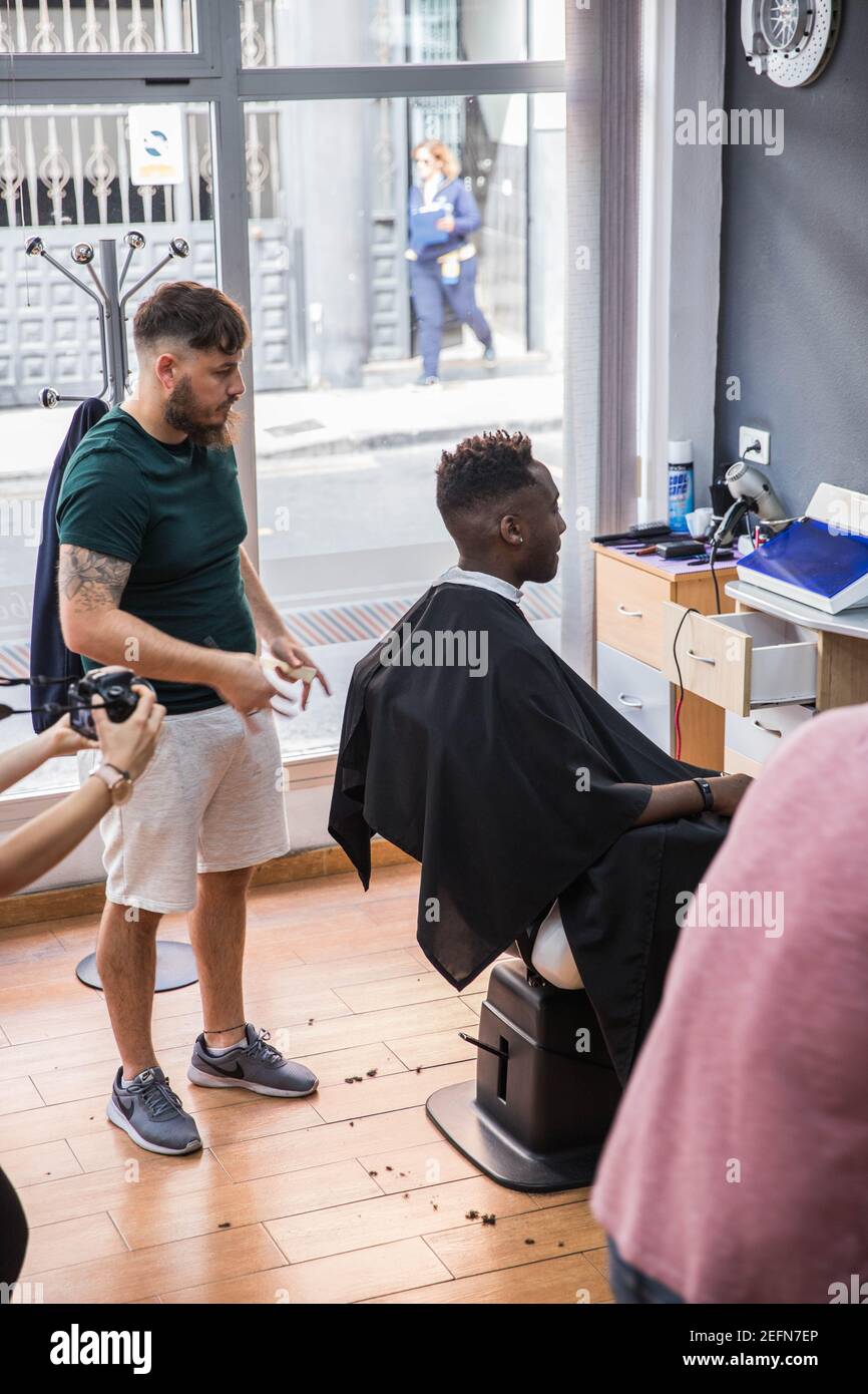 Hipster Barber checks how the haircut fits to his client Stock Photo ...