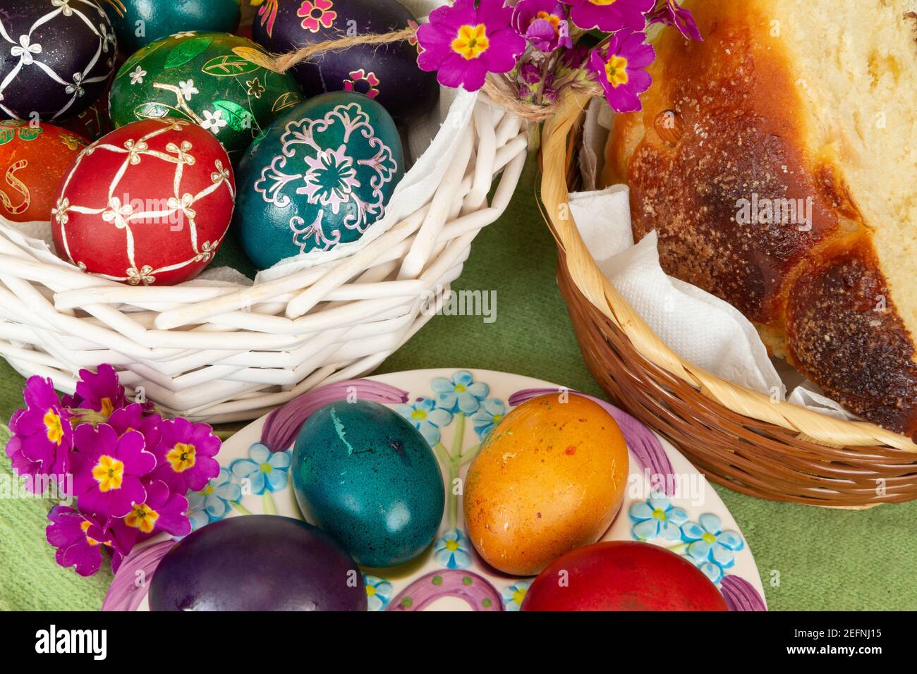 Easter eggs and Easter bun with flowers - green background Stock Photo ...