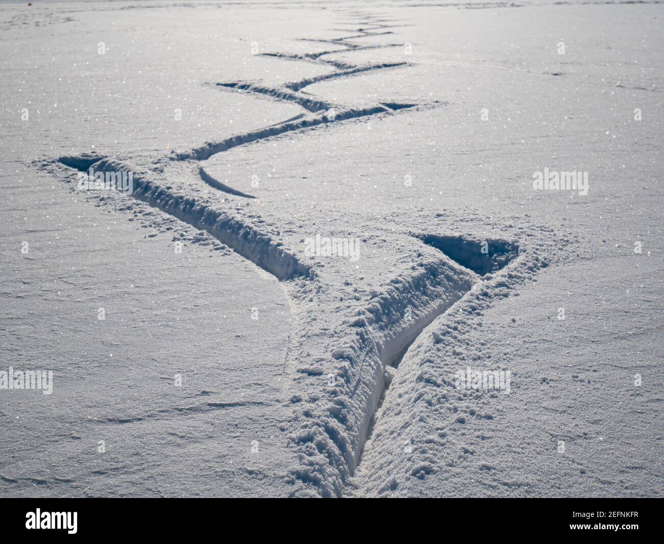 Bright snow traces of ice skating on an ice. Frozen mountain lake ...