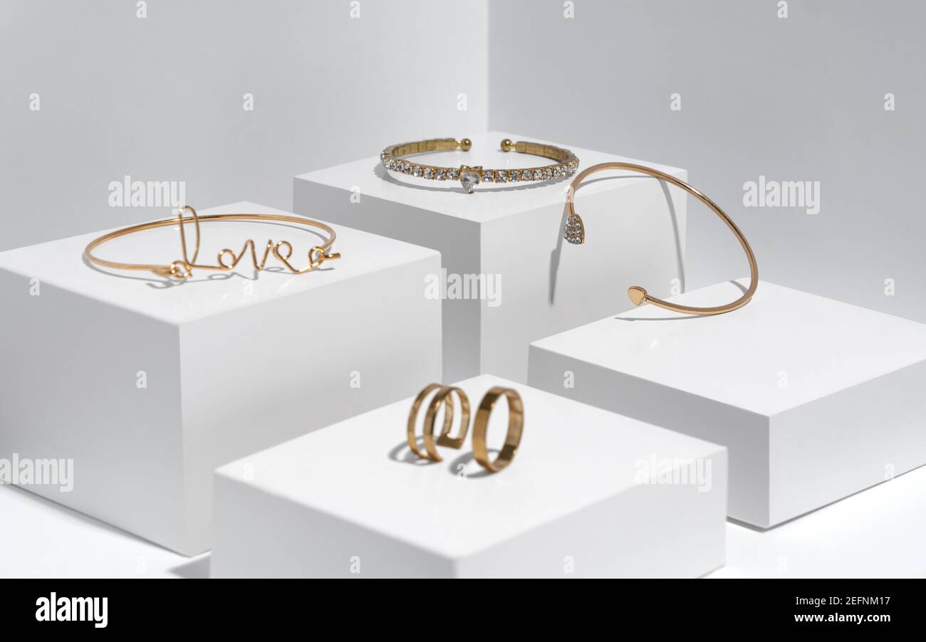 Golden bracelets and ring on white boxes Stock Photo - Alamy